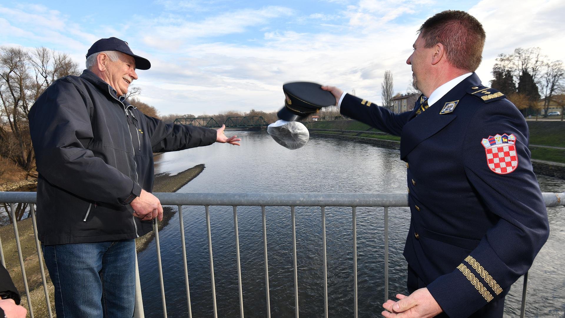 (FOTO) Praznična tradicija policistov: kape so zmetali v Muro ...